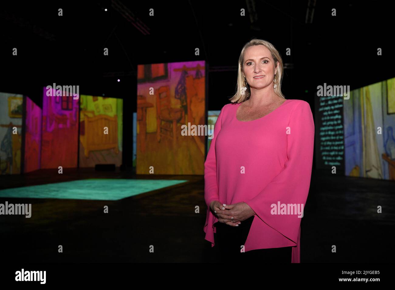Promoter Emma Triggs poses for a photo as artworks are projected during ...