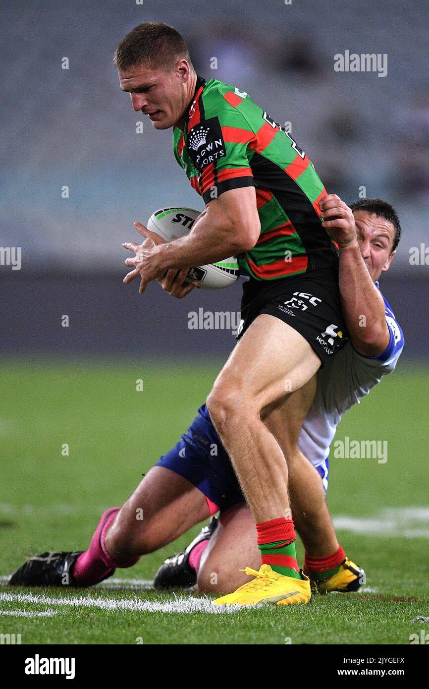 Jed Cartwright of the Rabbitohs is tackled by Josh Jackson of the ...