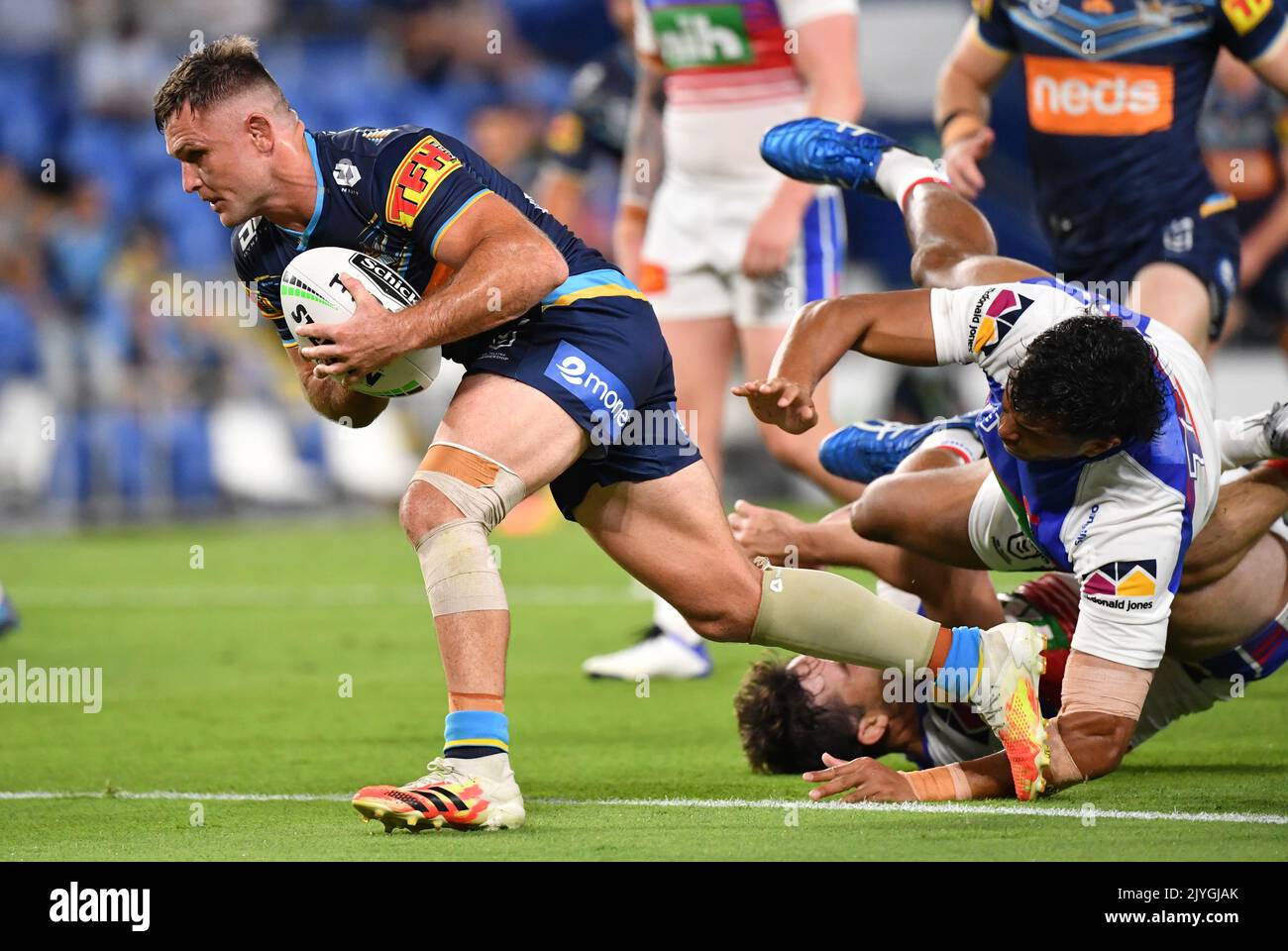 Mitch Rein (left) of the Titans gets past the Knights defence to score ...