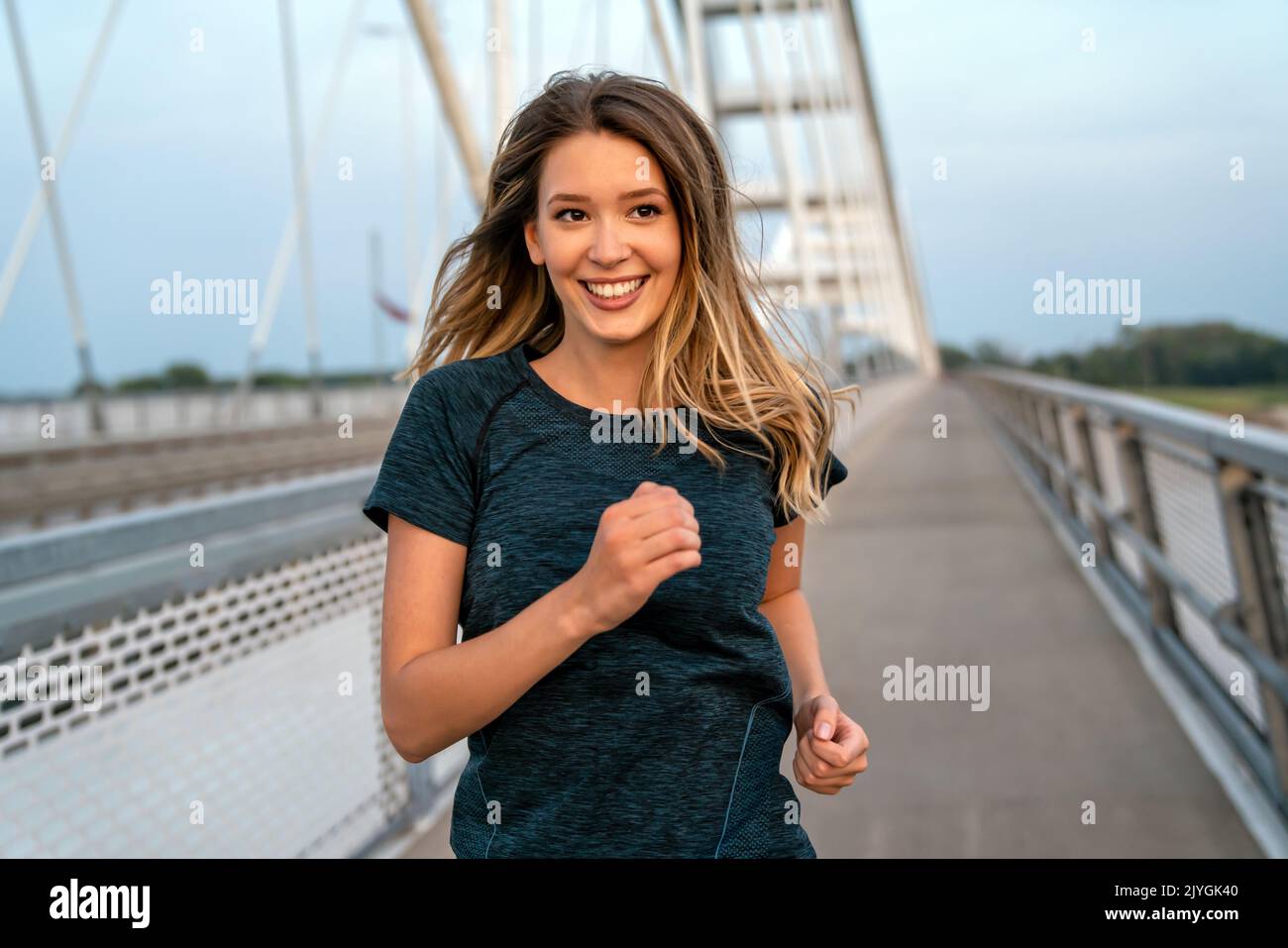 Portrait of young fit attractive happy fitness woman in city. People ...