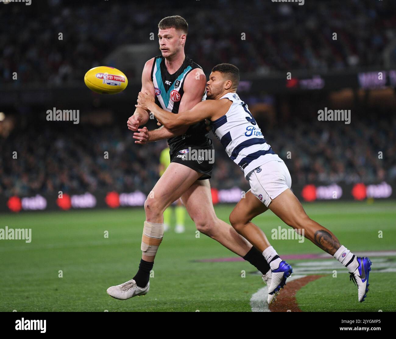 Peter Ladhams of the Power is tackled by Brandon Parfitt of the Cats ...