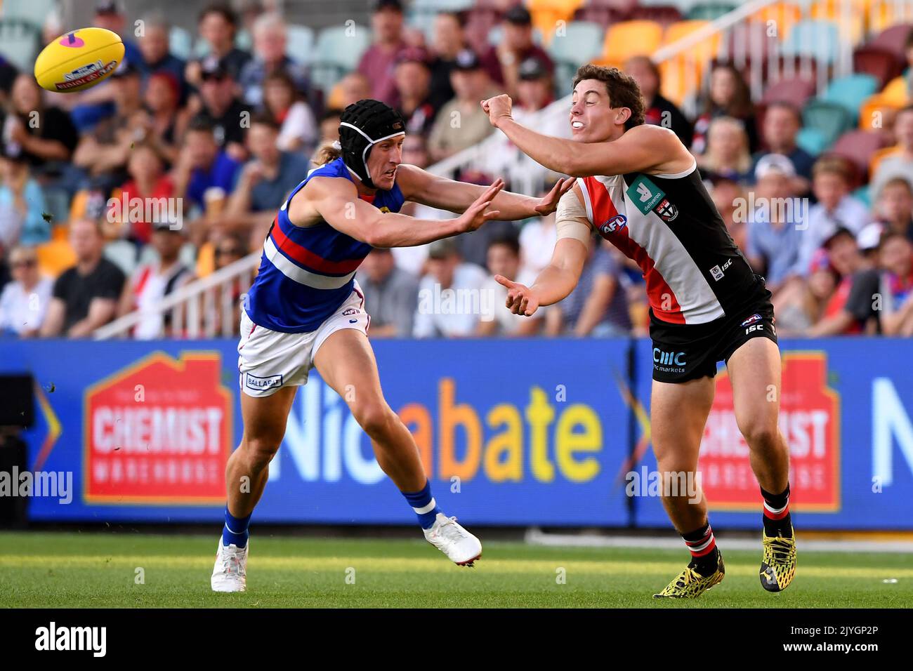Nick Coffield of the Saints handpasses as Aaron Naughton of the ...