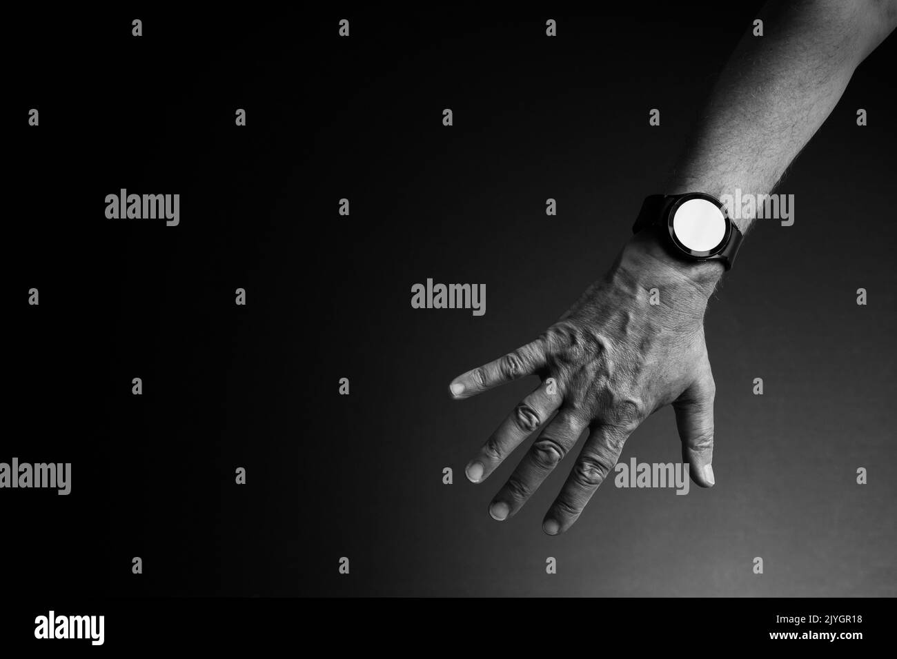 Black and white image of man's hand with smart watch on wrist ...