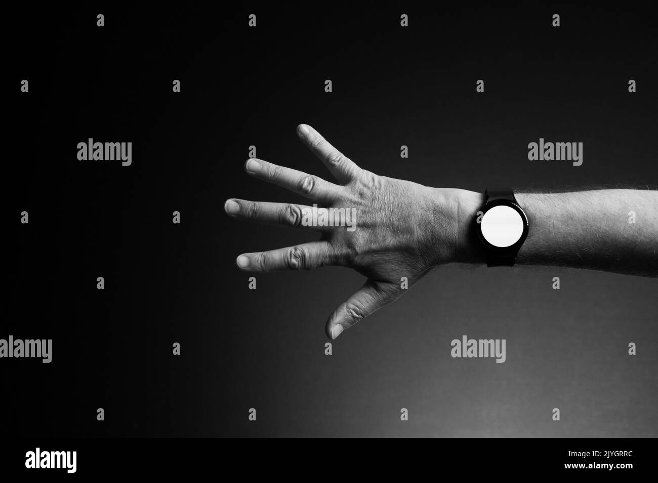 Black and white image of man's hand with smart watch on wrist ...