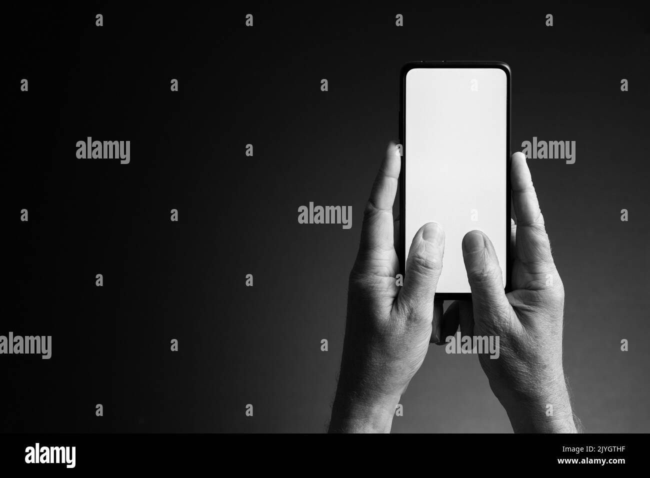 Black and white image of man's hands holding smart phone and texting ...