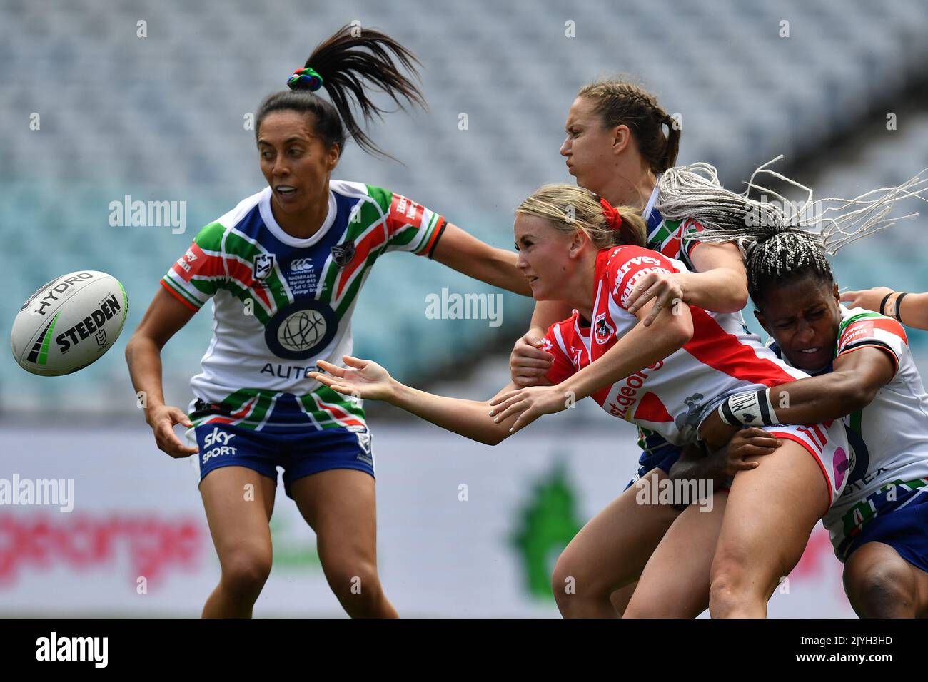 Jaime Chapman of the Dragons off loads as she's tackled by Ellia Green ...