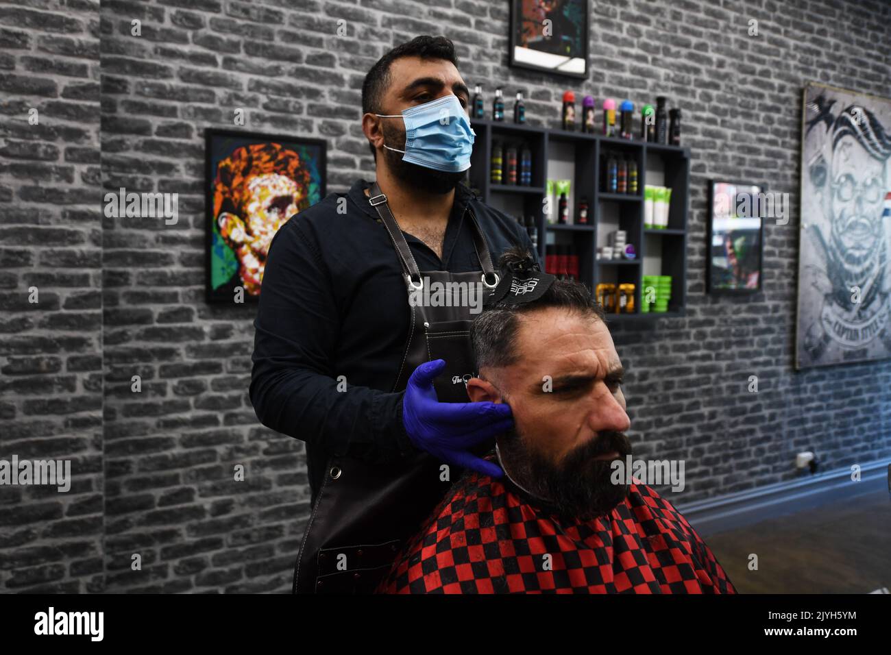 Barber Ethan Hemtyar (left) gives client Carlo Greco a hair cut at ...