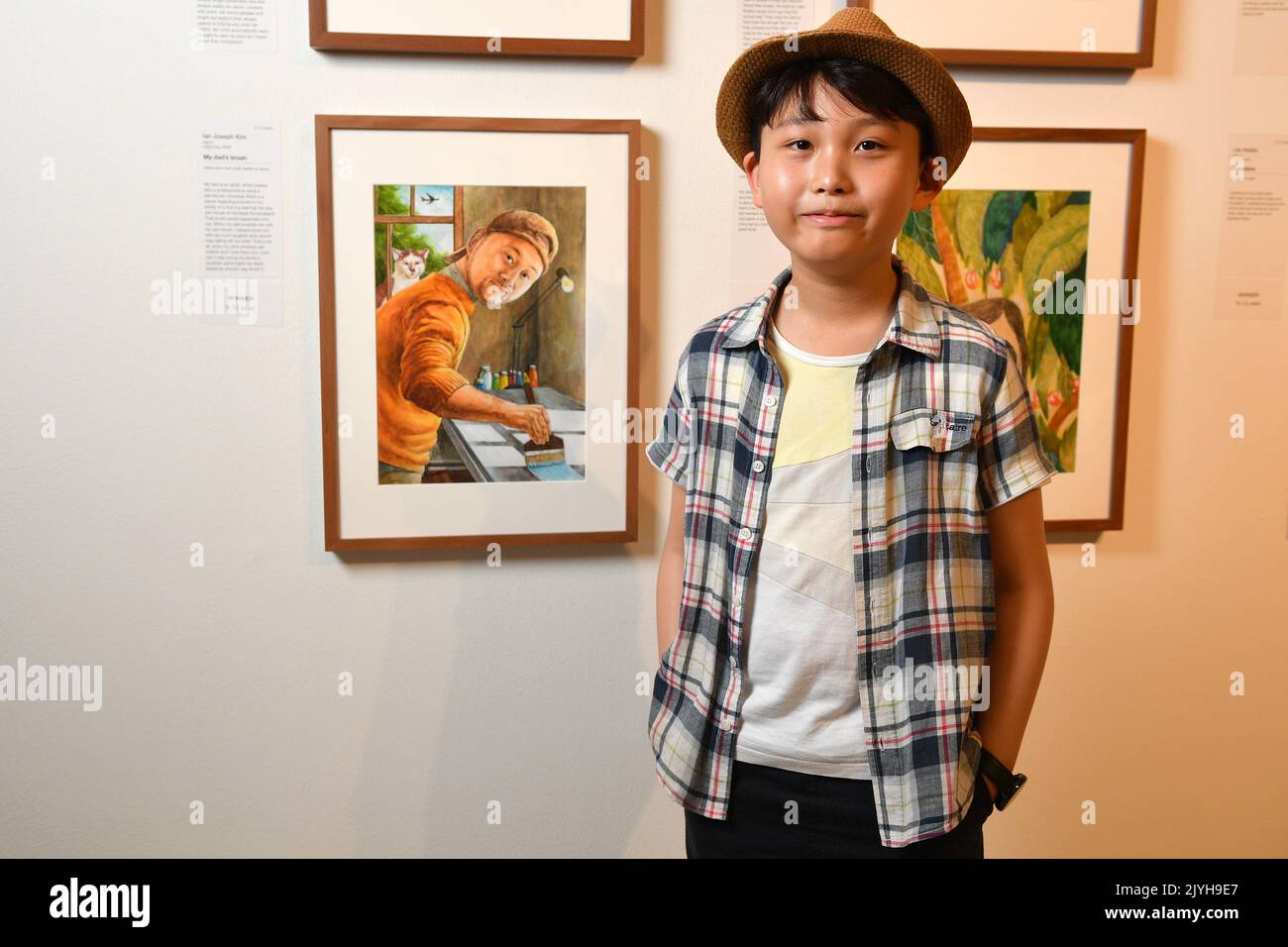 Ian Joseph Kim, 9, poses for a photograph with his artwork after being ...