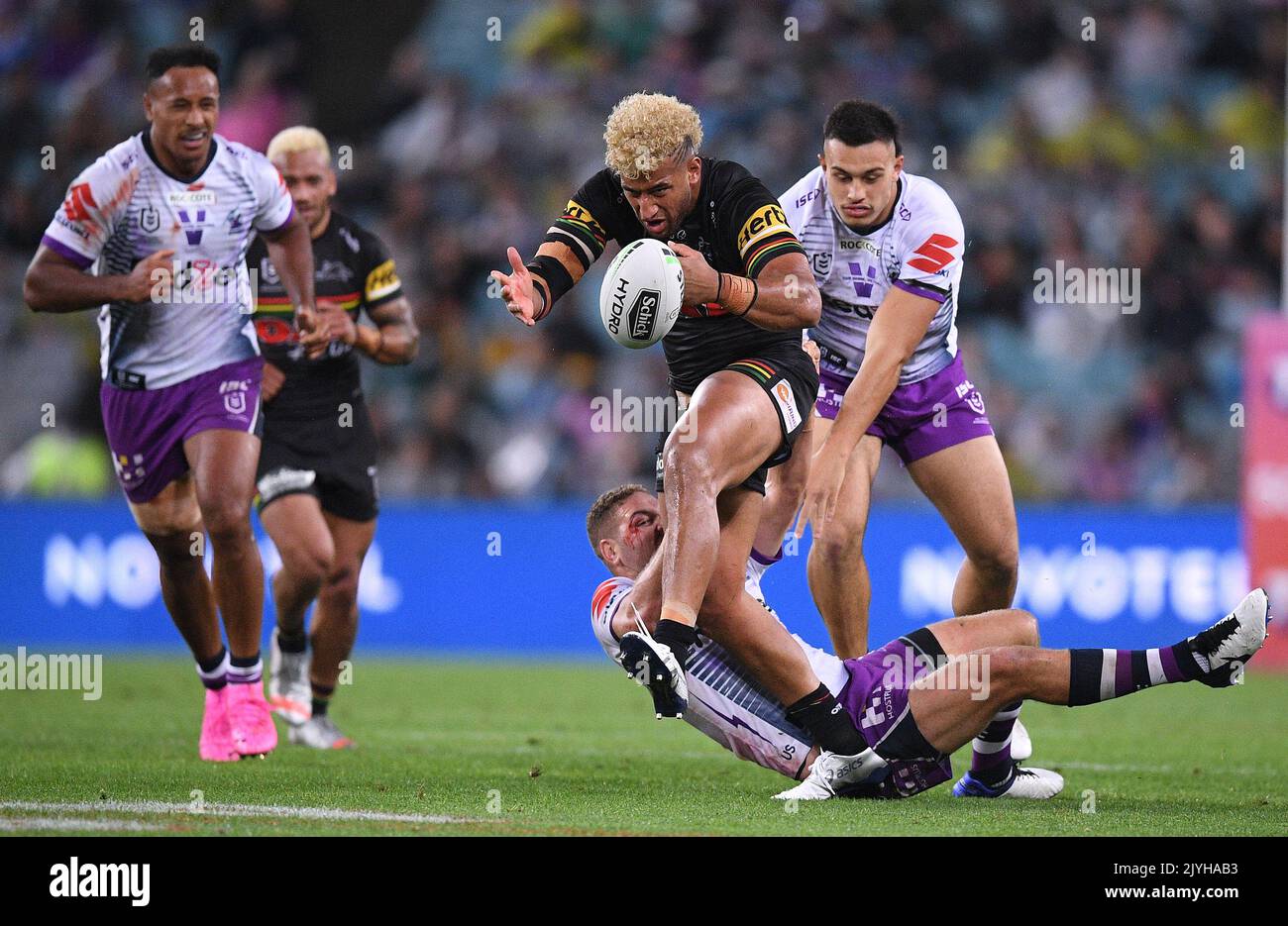 Village Kikau of the Panthers loses the ball forward as he is tackled Brenko Lee of the Storm ...
