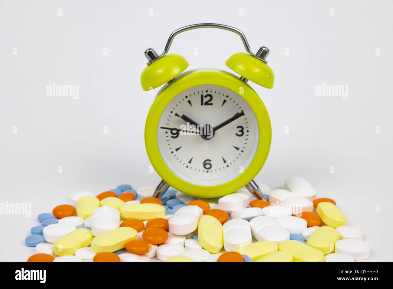 Using medicines in time concept. Clock on the pills isolated on white ...