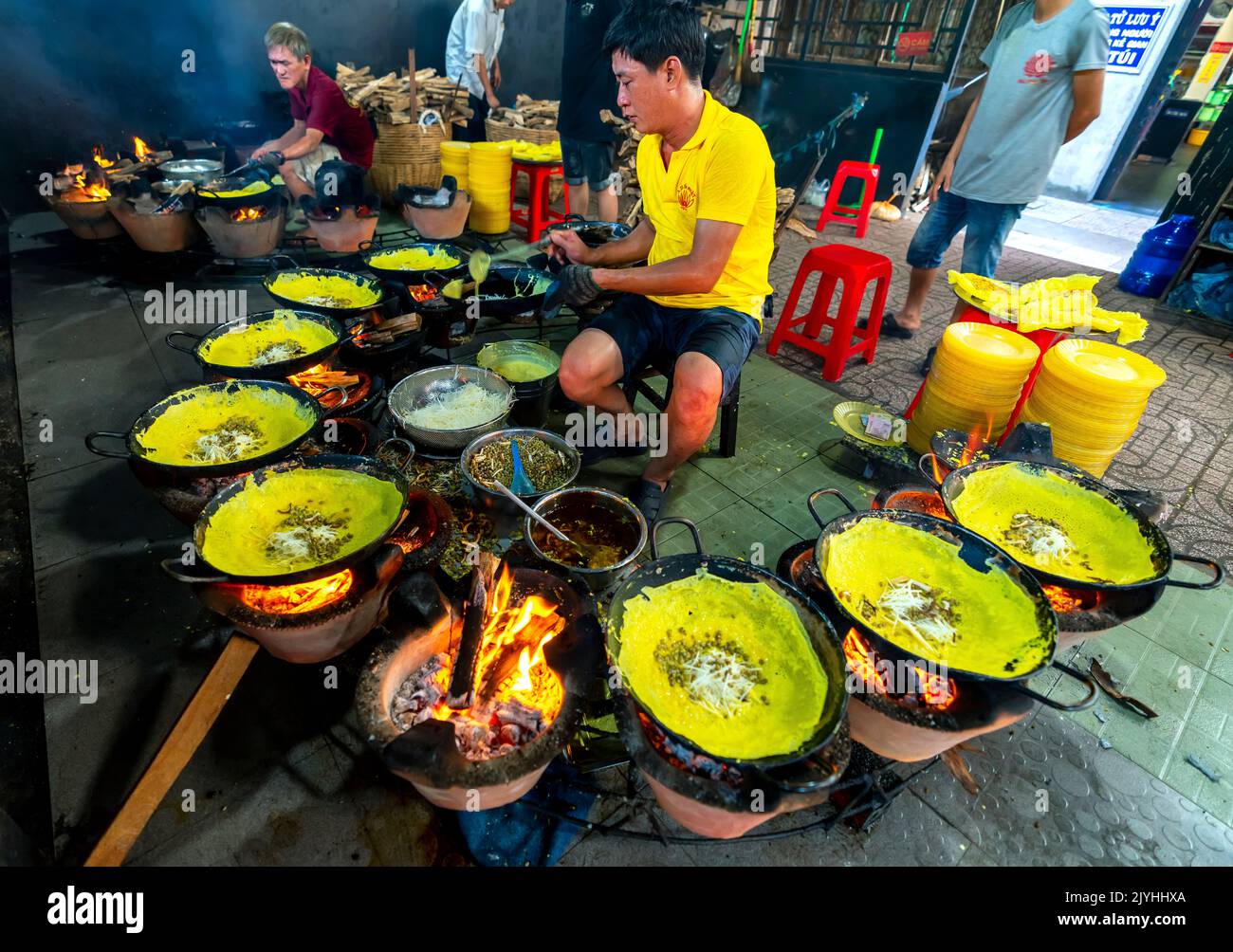 A man Baker is making Banh Xeo on the surrounding braziers, vegetarian ...
