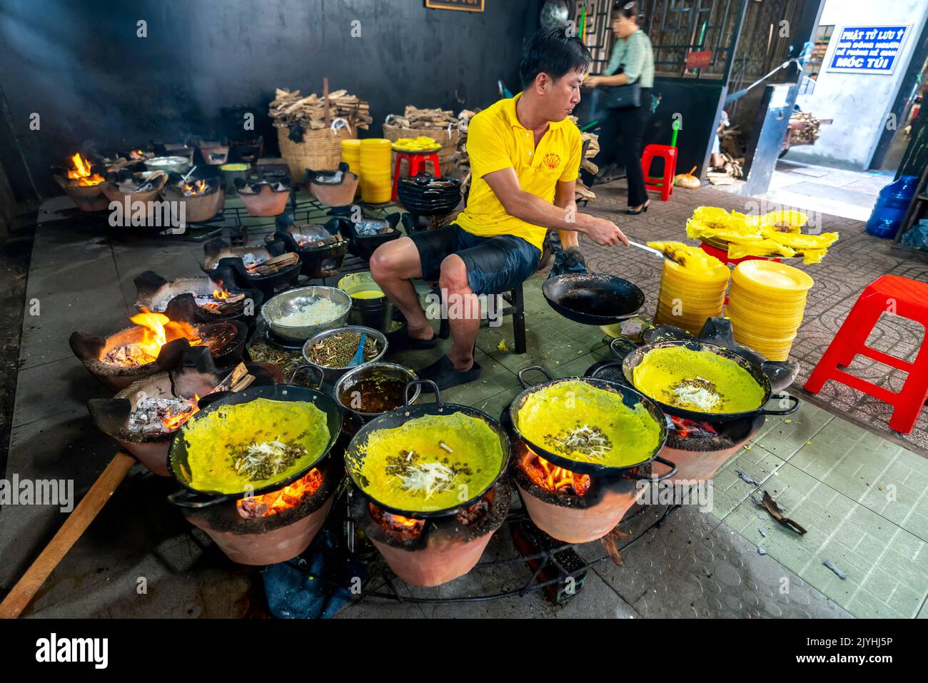 A man Baker is making Banh Xeo on the surrounding braziers, vegetarian ...