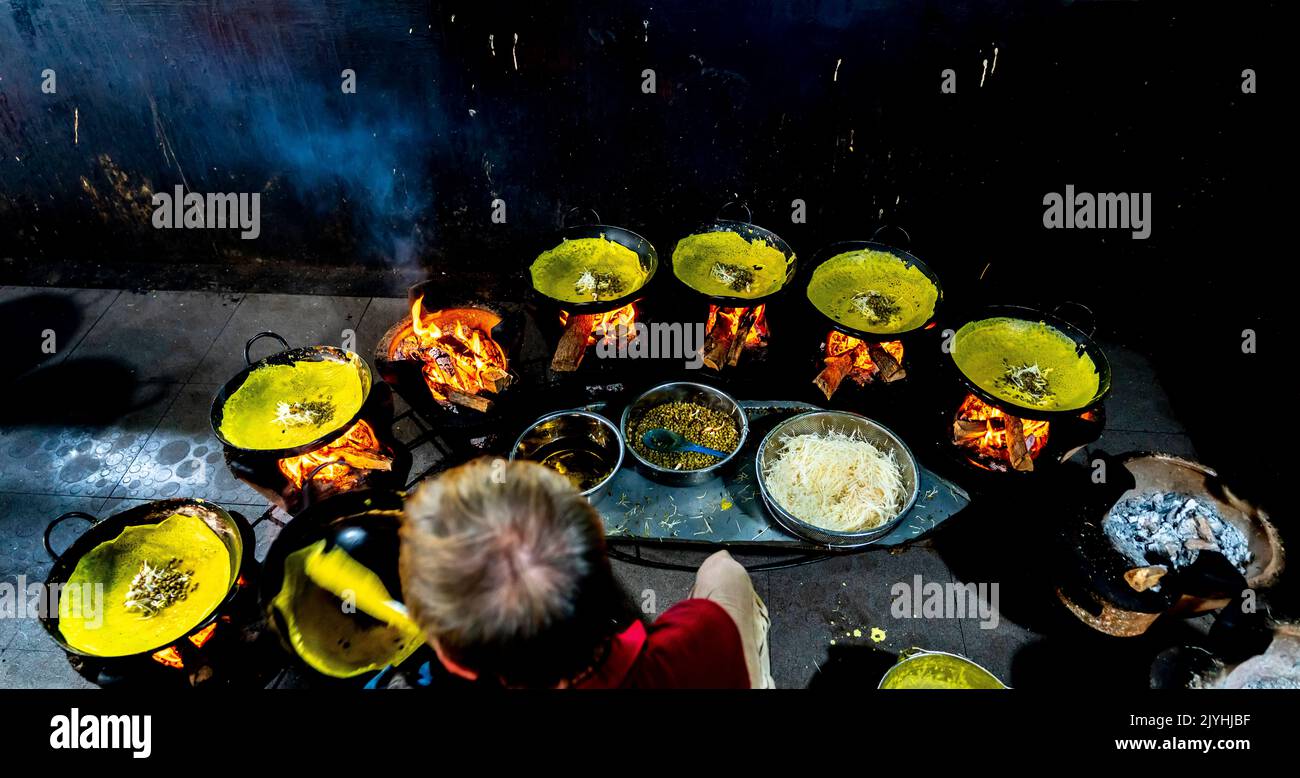 A man Baker is making Banh Xeo on the surrounding braziers, vegetarian ...