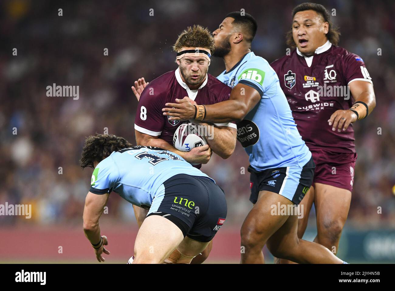 Christian Welch of the Maroons (centre) is tackled by Angus Crichton of ...