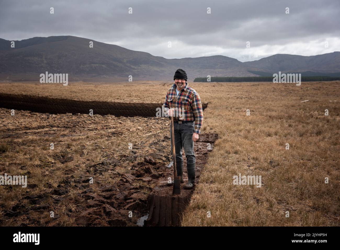 A turf cutter in the middle of the extensive peat bog on the edge of ...