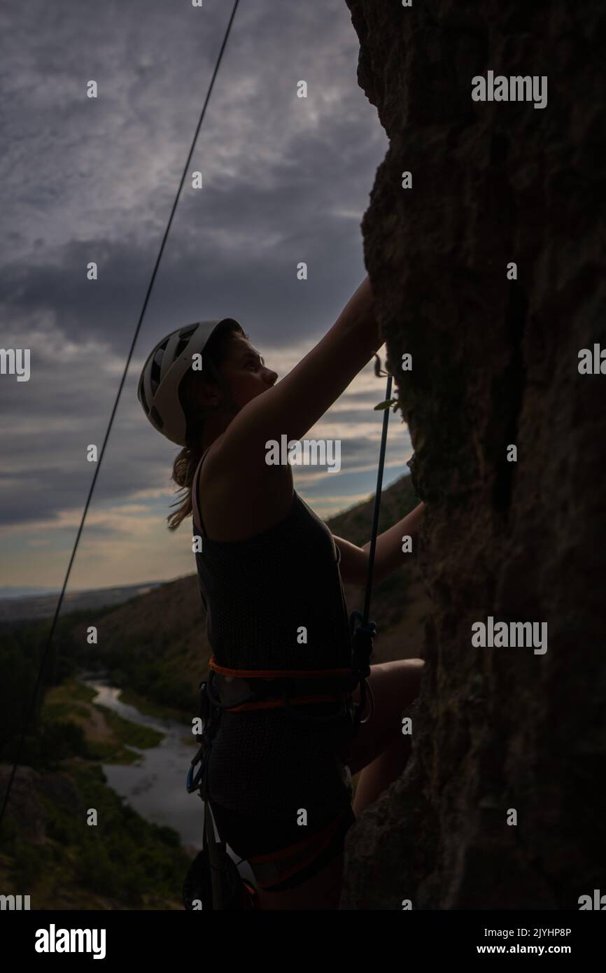 Silhouette of a beautiful girl is climbing the high hill while thinking ...