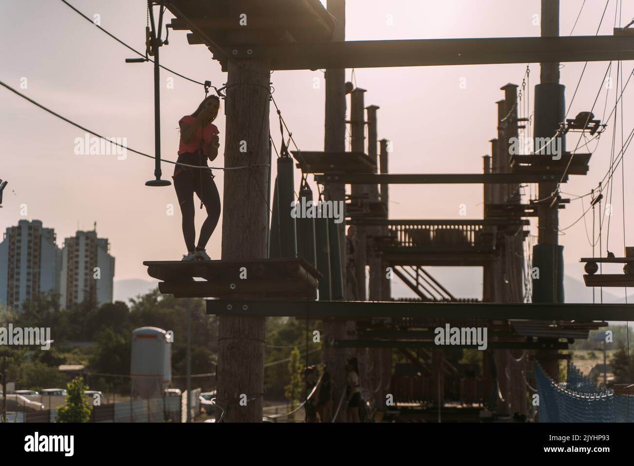 Strong adventure girl standing high at the adventure park Stock Photo ...