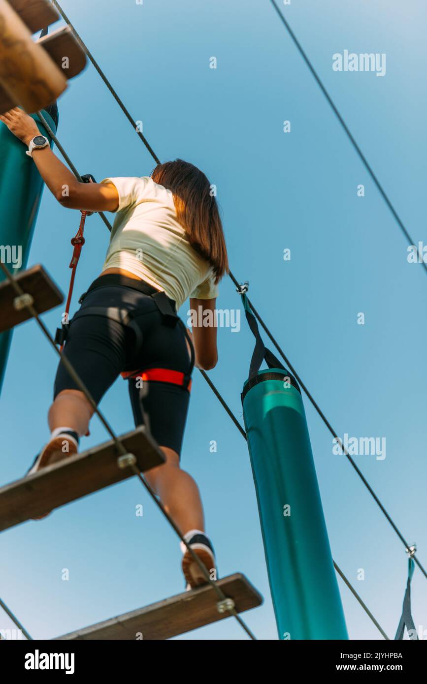 Young professional climber clearing the ladder obstacle with ease in ...