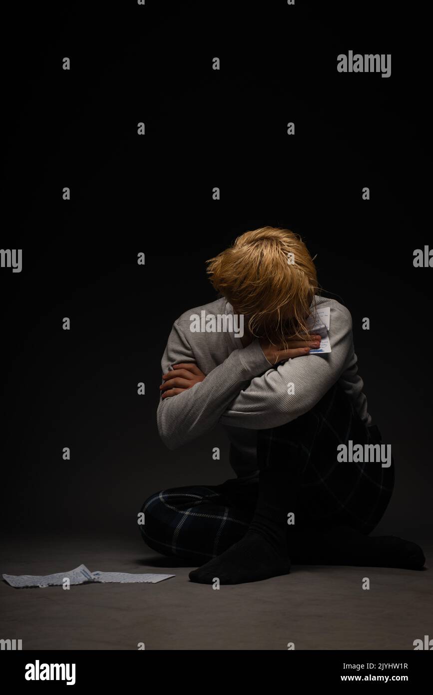 Depressed and sad boy is crying a lot about the letter he is holding ...