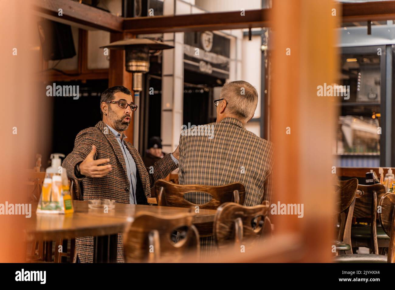 Two senior businessmen are explaining something to each other and ...