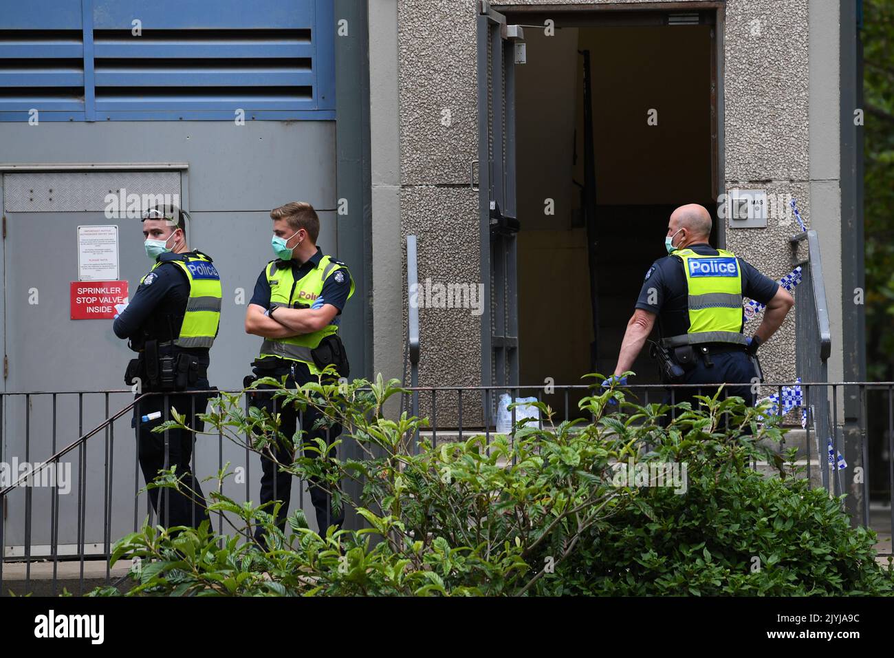 Victoria Police are seen at a crime scene outside of a public housing ...
