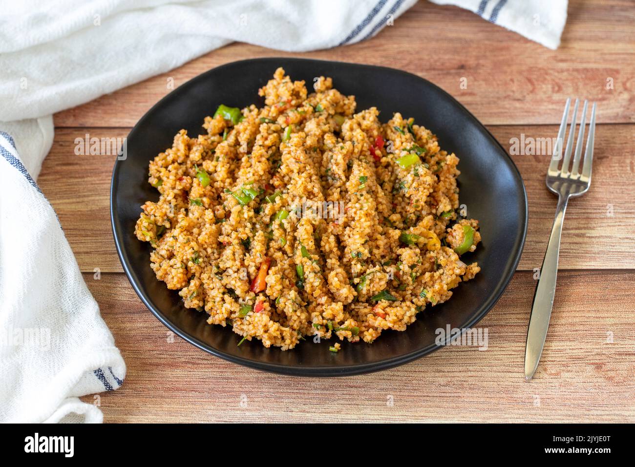 Bulgur salad on wood floor. An appetizer prepared with bulgur and green ...
