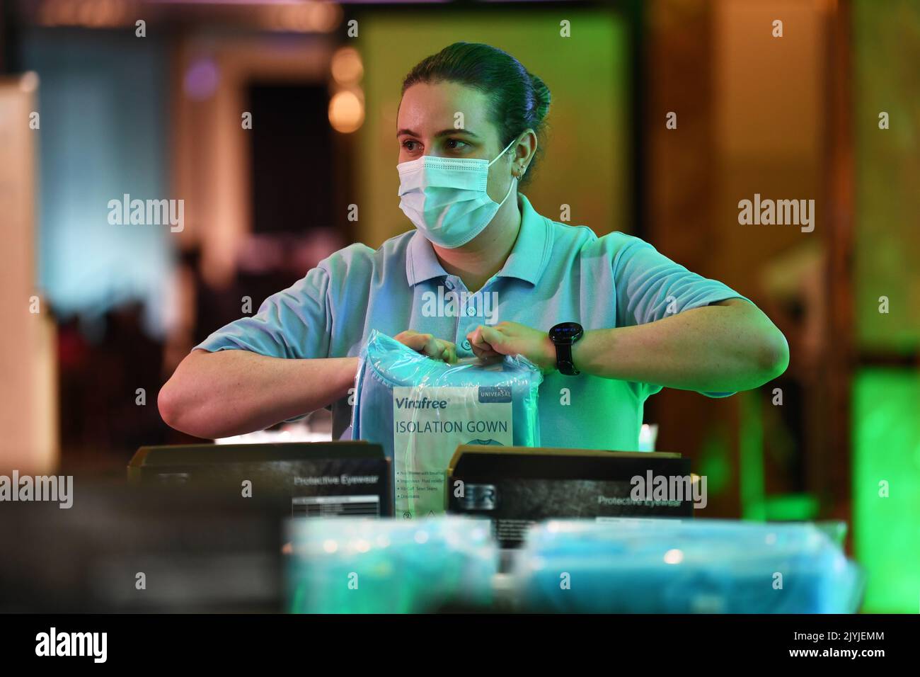 Healthcare workers are seen at a personal protective equipment station ...