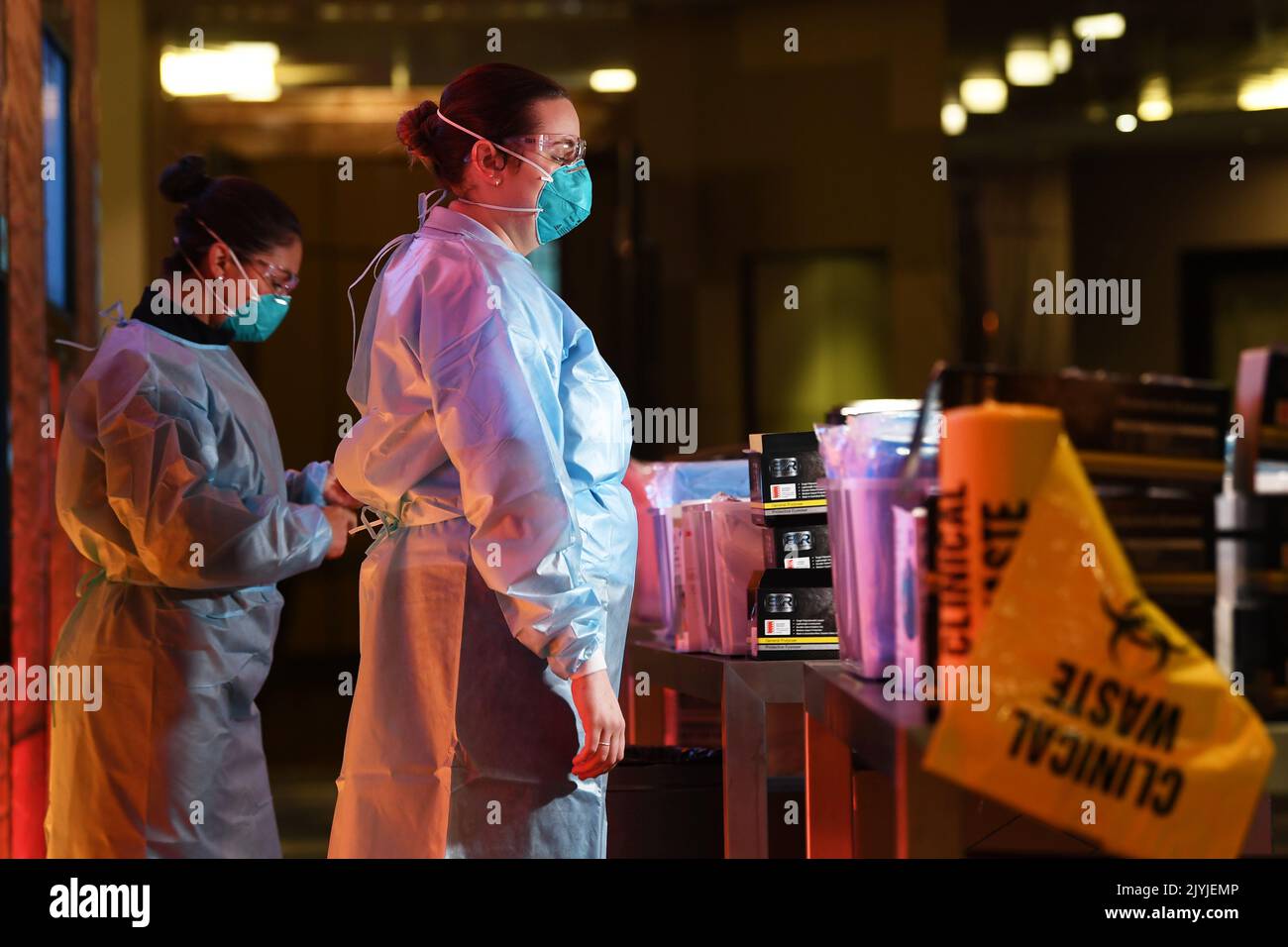 Health care workers are seen at a personal protective equipment station ...