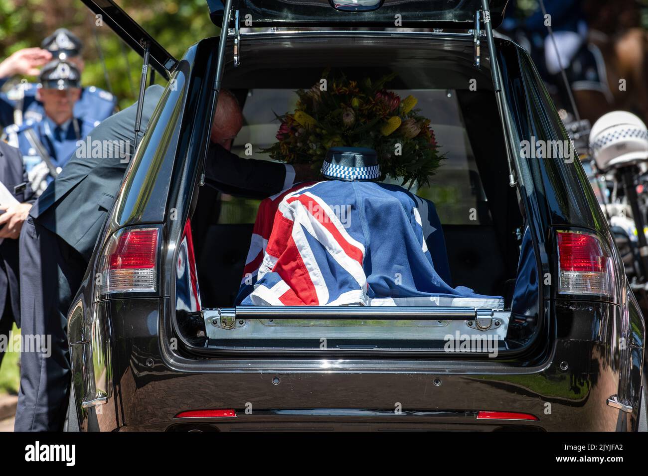 Flowers are placed on the casket during the police funeral of Senior ...