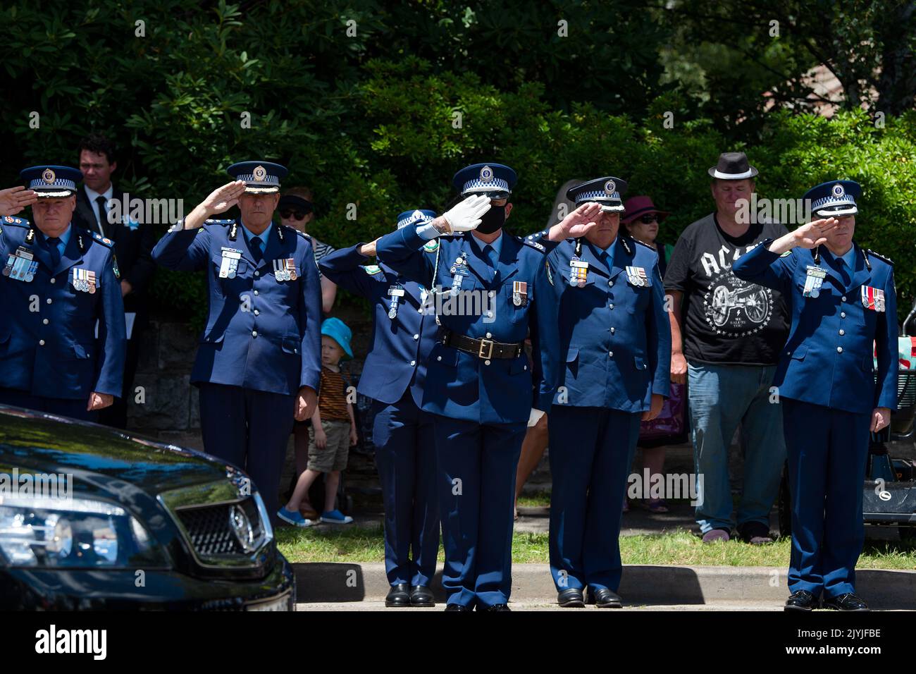 Members of NSW Police salute as the hearse proceeds through the town at ...