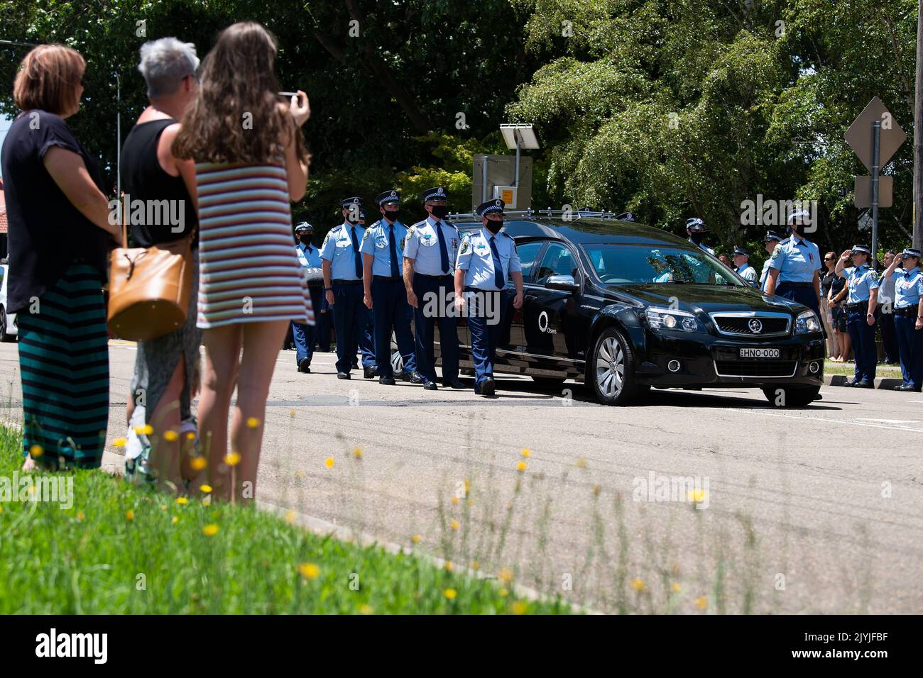 People are seen lining the street as the hearse proceeds through the ...