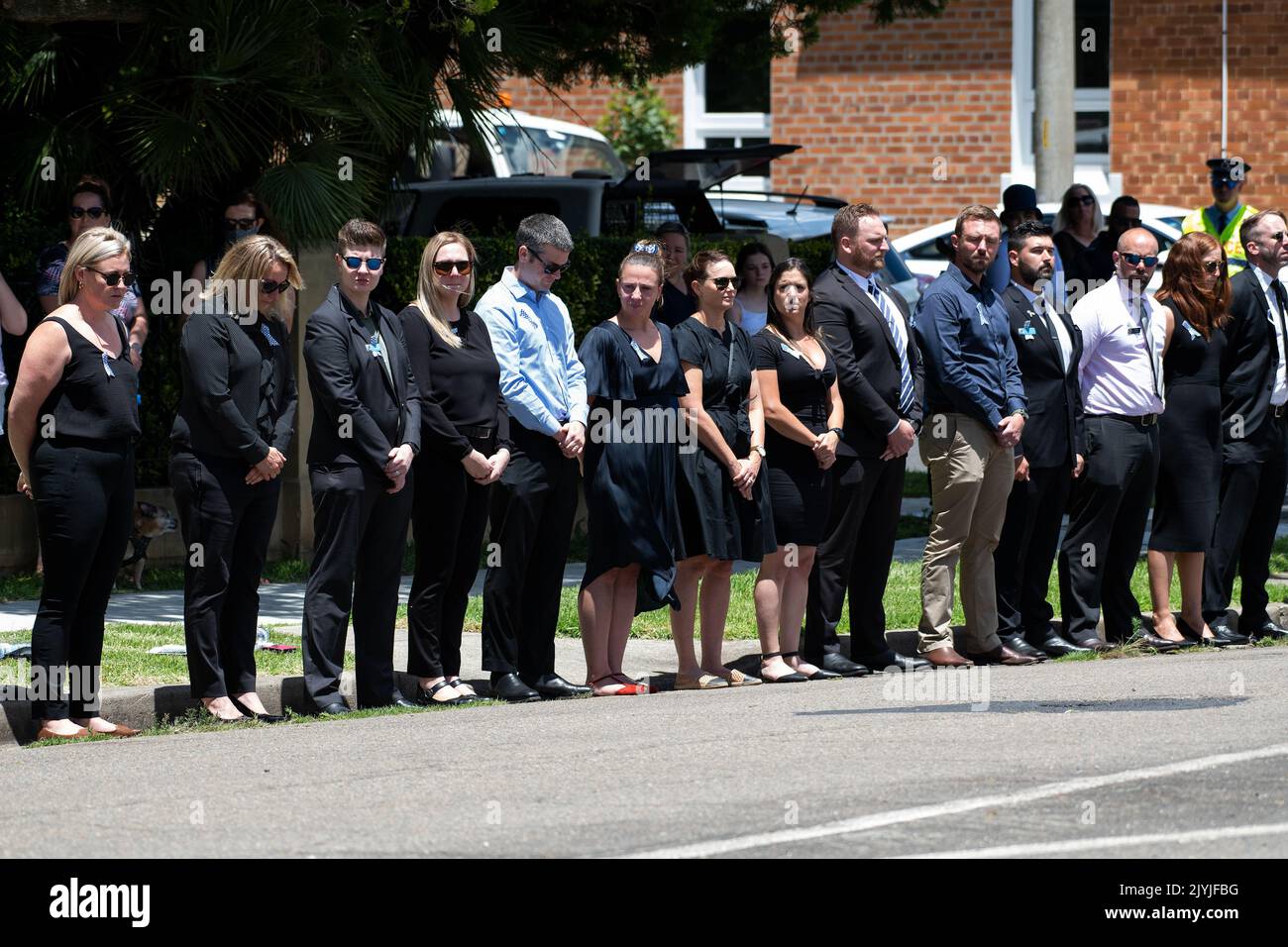 People are seen lining the street as the hearse proceeds through the ...