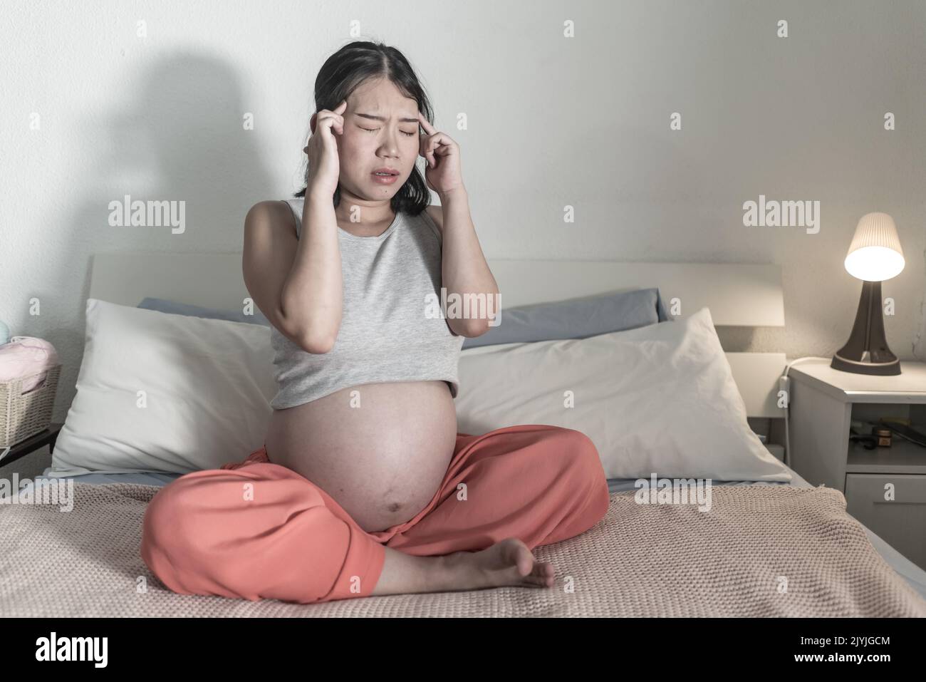 home portrait of young tired and depressed Asian Korean woman pregnant ...