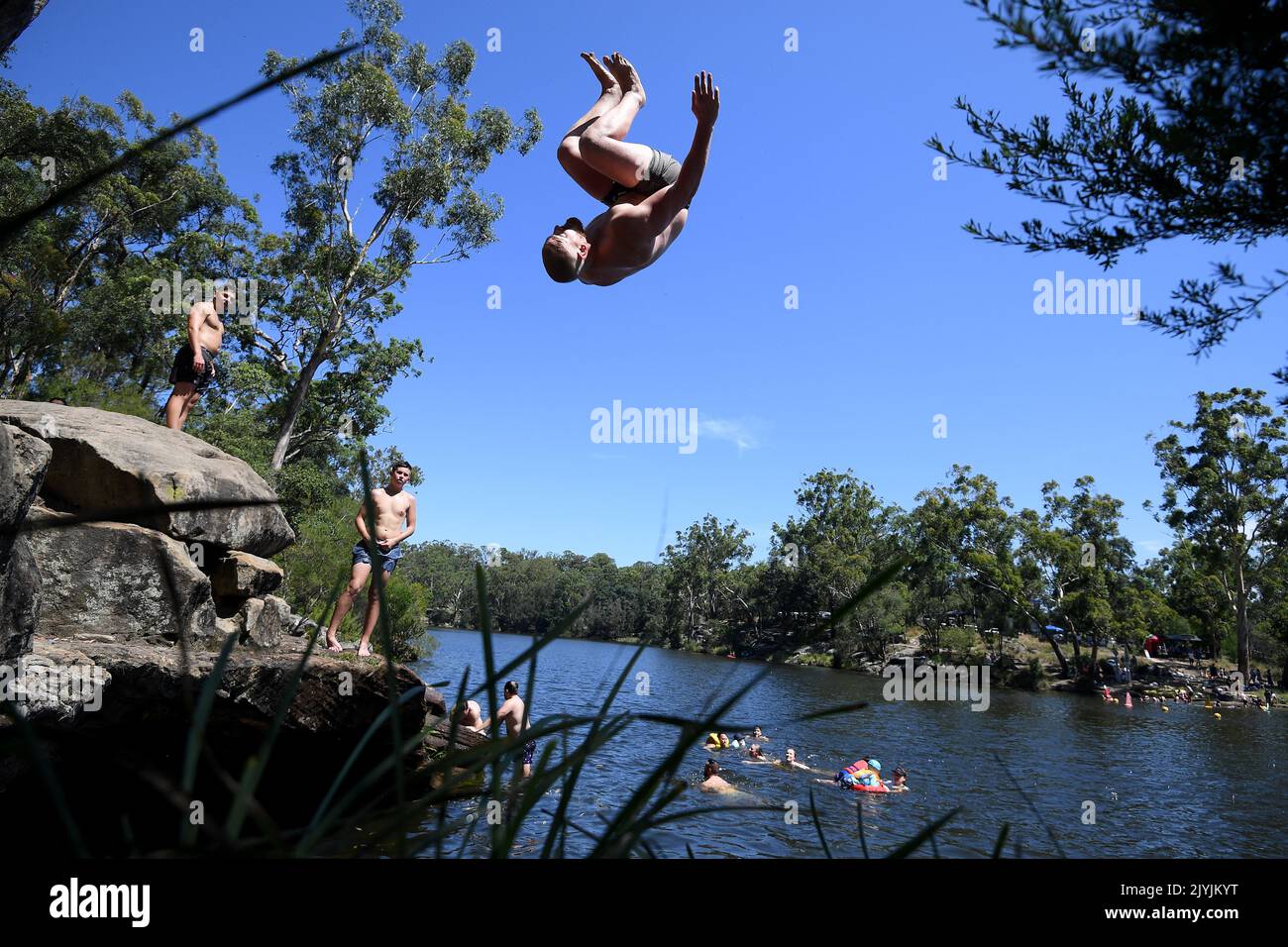 Swimmers are seen jumping off a rock at Lake Parramatta, in Parramatta, west of Sydney, Saturday ...