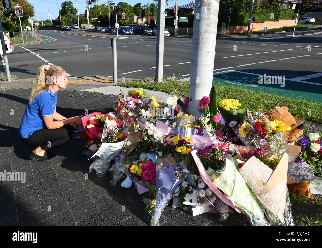 A women is seen laying flowers at the scene where two pedestrians ...