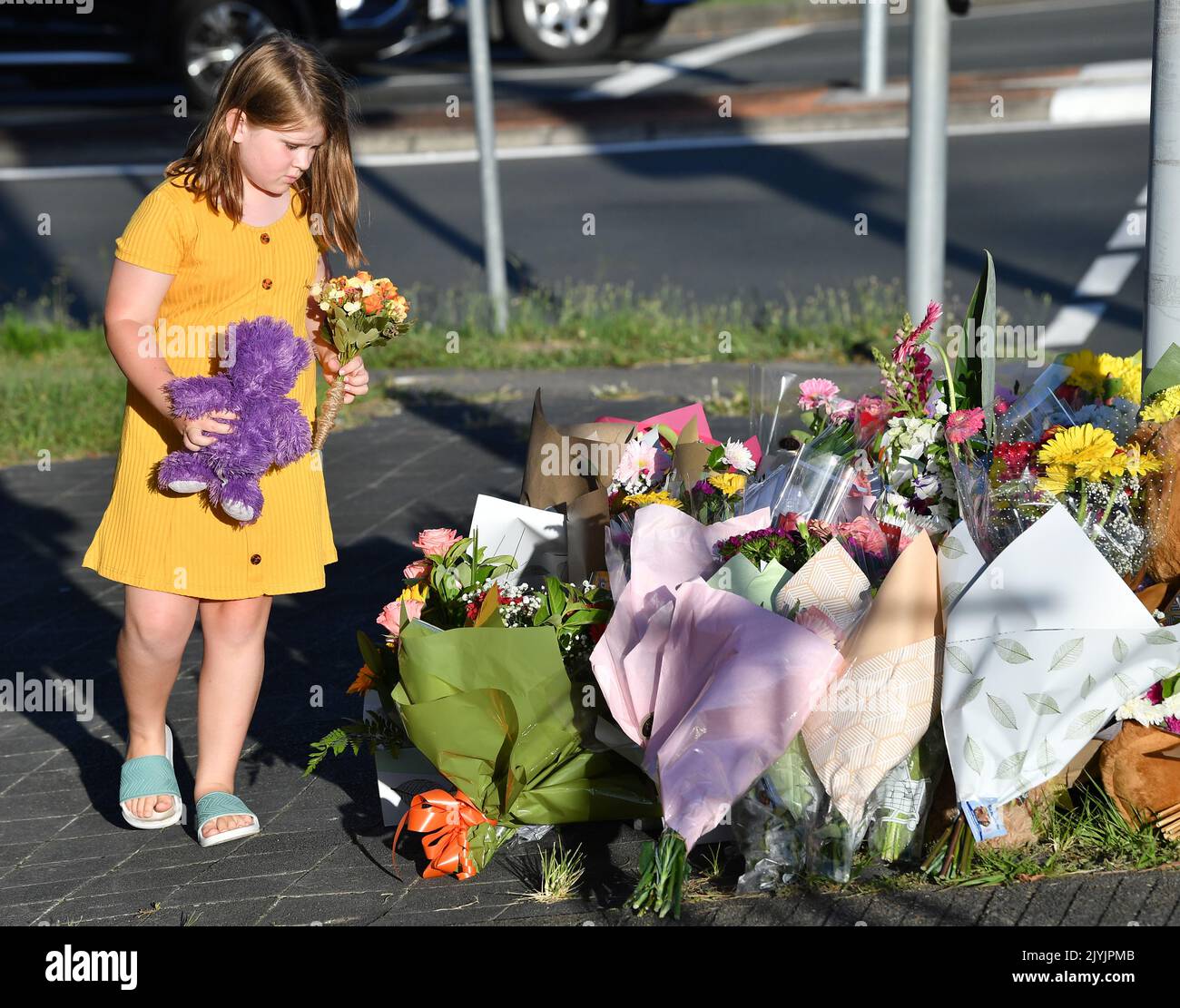 A child is seen laying flowers at the scene where two pedestrians, Kate ...