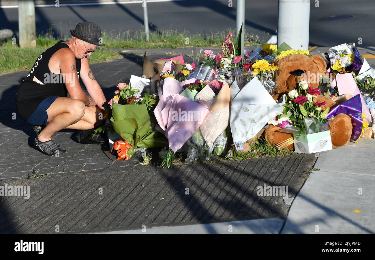 A women is seen laying flowers at the scene where two pedestrians ...