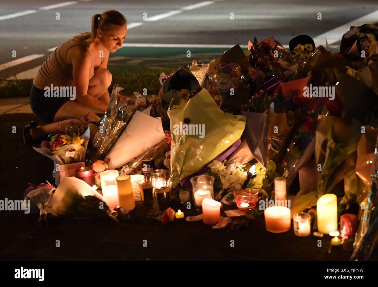A women is seen laying flowers at a vigil for Kate Leadbetter, 31, and ...