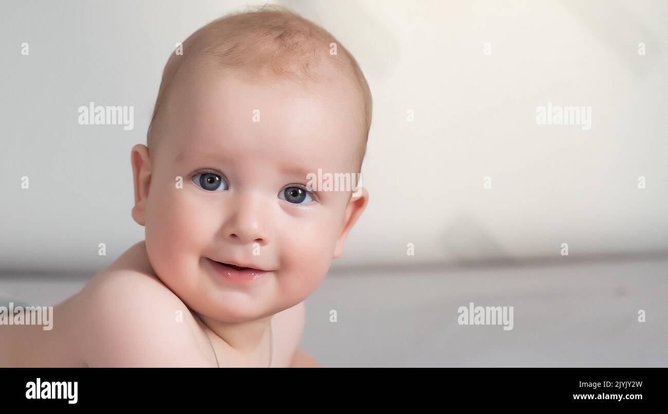 Cute smiling baby on a gray couch Stock Photo - Alamy