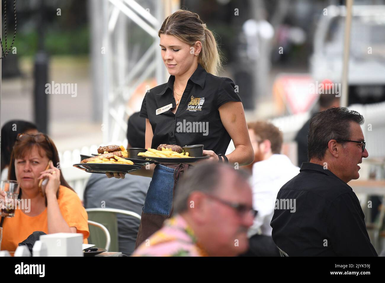A waitress serves diners at a bar in Sydney, Friday, February 12, 2021 ...