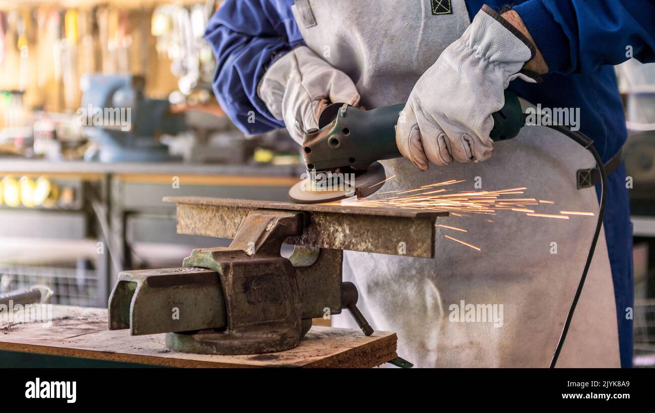 Metal processing with a man using angle grinder to cleaning the steel ...