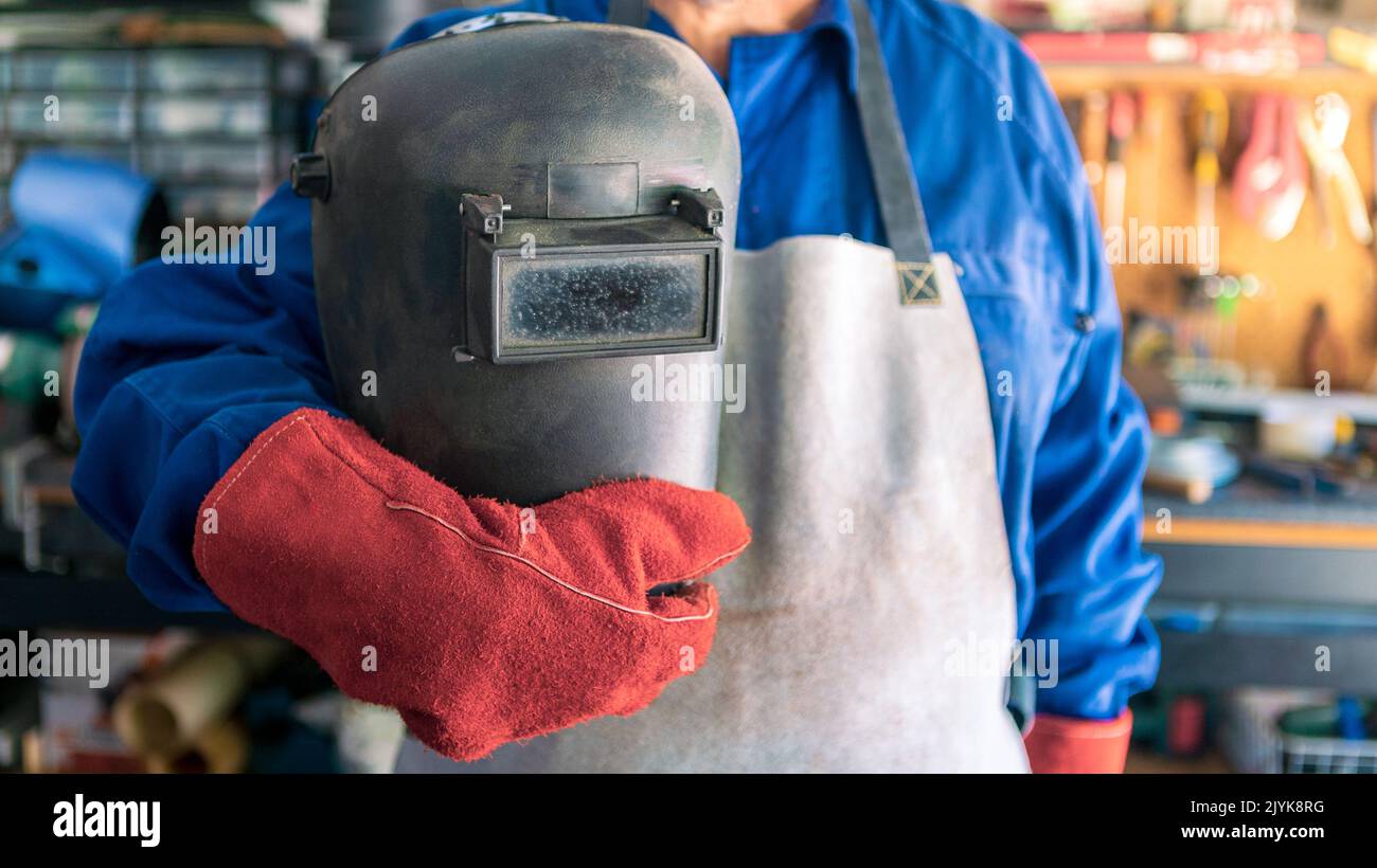 A man welder with safety helmet working with arc welding machine in the ...