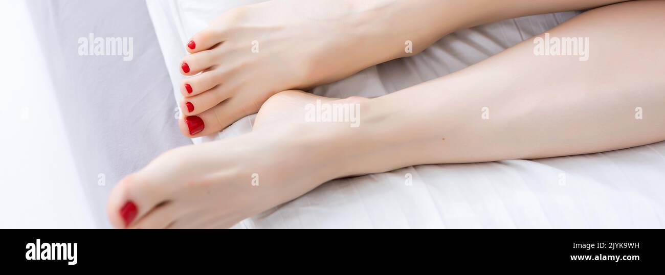 Woman legs on the bed with white bed clothes Stock Photo - Alamy