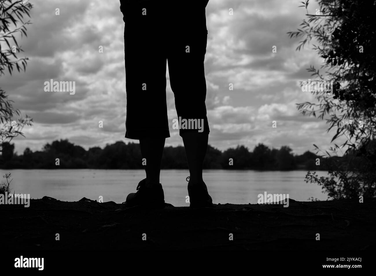 Black & white silhouette of lower legs of person in long shorts/cut-off ...