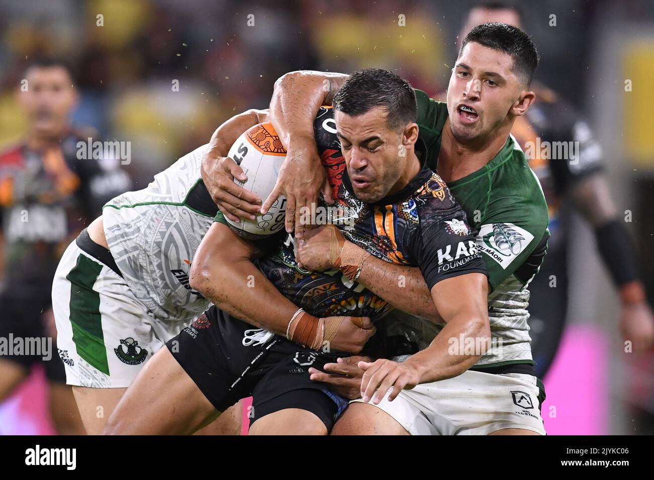 Corey Thompson (centre) of the Indigenous All Stars is tackled by ...