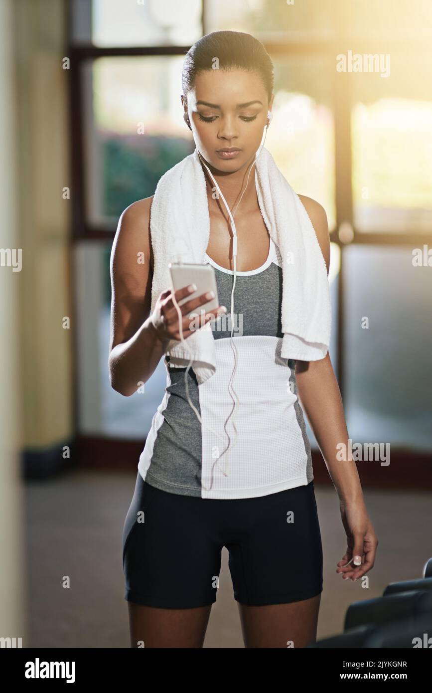 Choosing the perfect playlist for her workout. a young woman listening ...
