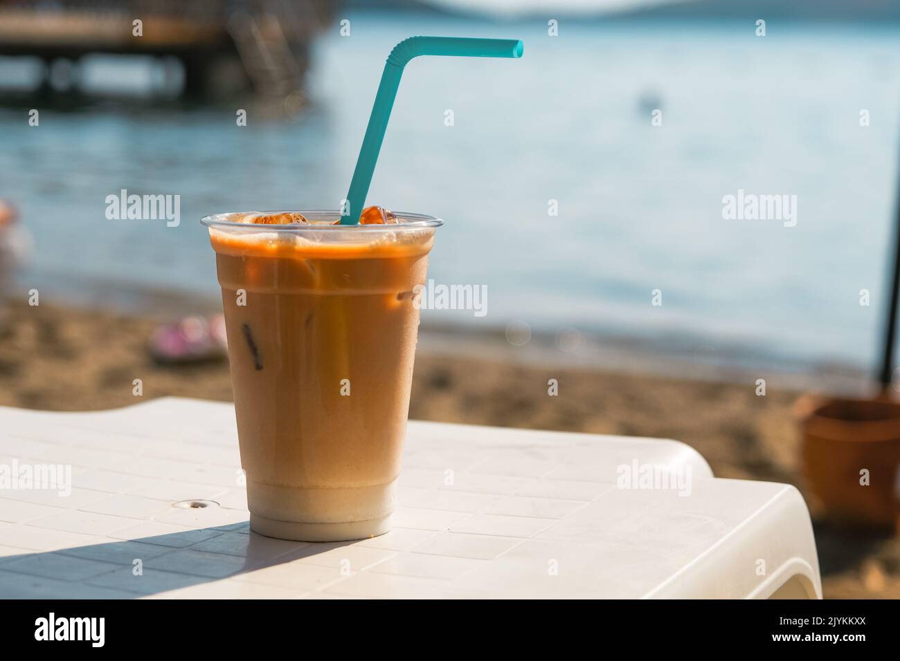 Ice latte coffee in plastic glass on the beach Stock Photo - Alamy