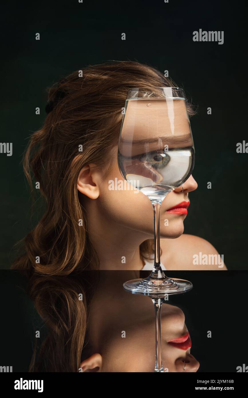Creative art photography. Closeup girl's face through wine glass over ...