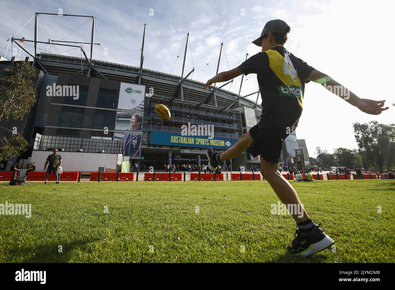 Fans kick the footy outside the MCG ahead of the Round 1 AFL match ...