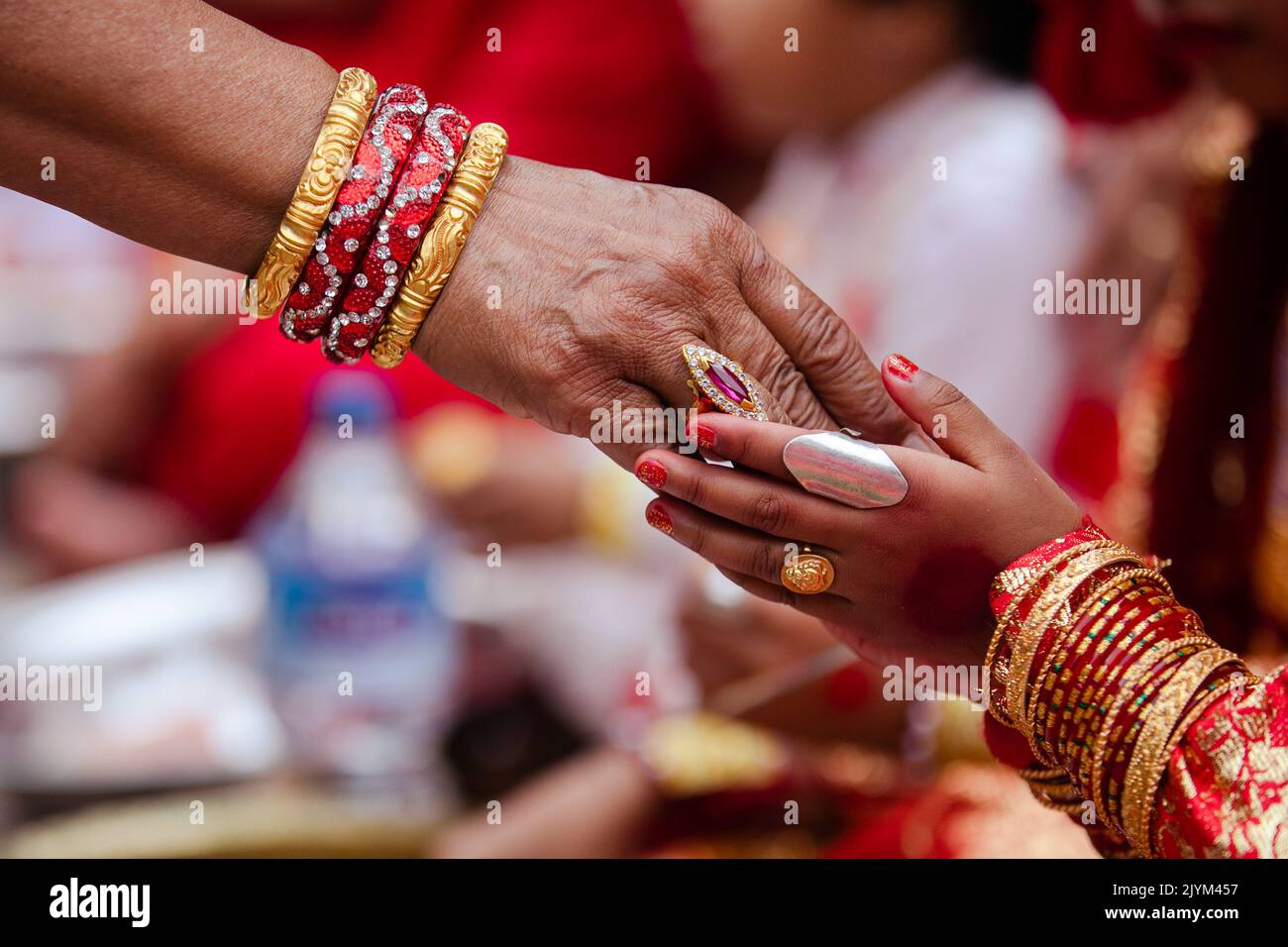 A woman offers prayers to the hand of a child who is dressed as the ...